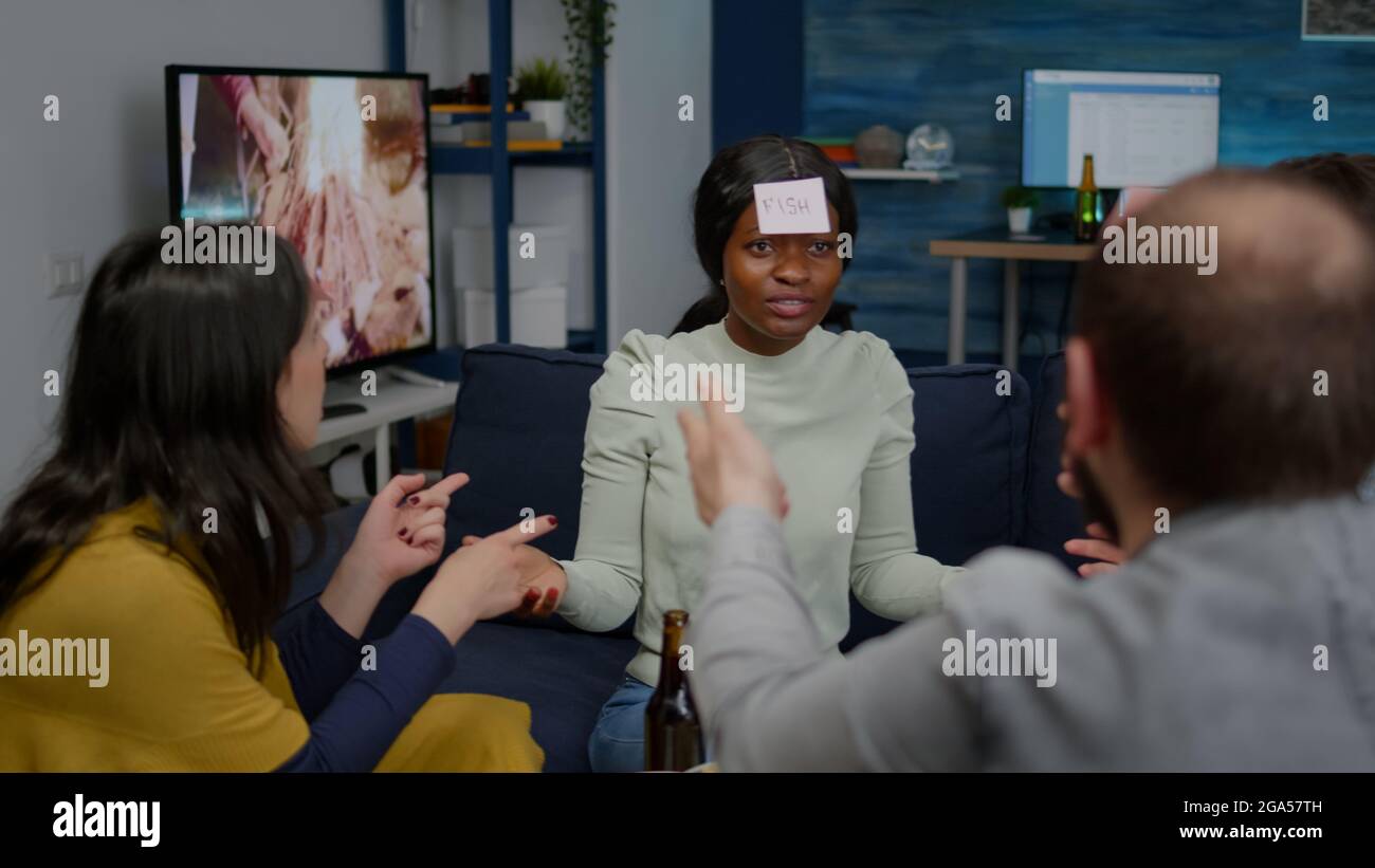 Multiethnic friends having attaching sticky notes on forehead while ...