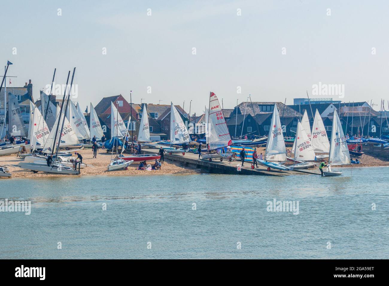 Group of sailors preparing their boats to set sail on the beach at ...