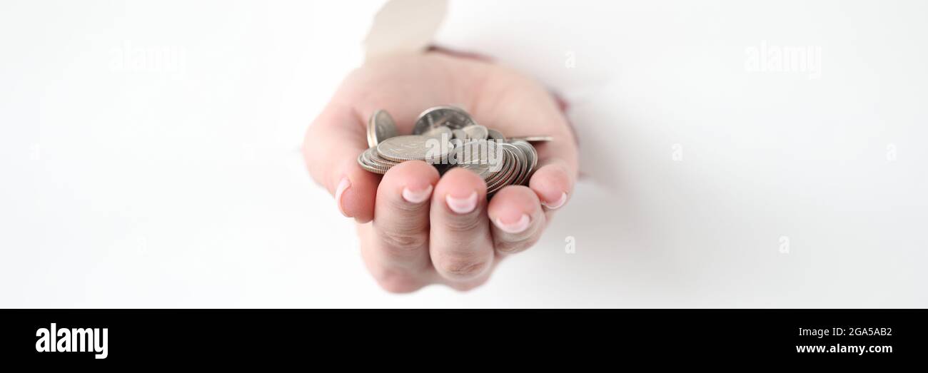 Hand pulling out bunch of coins from torn paper Stock Photo - Alamy