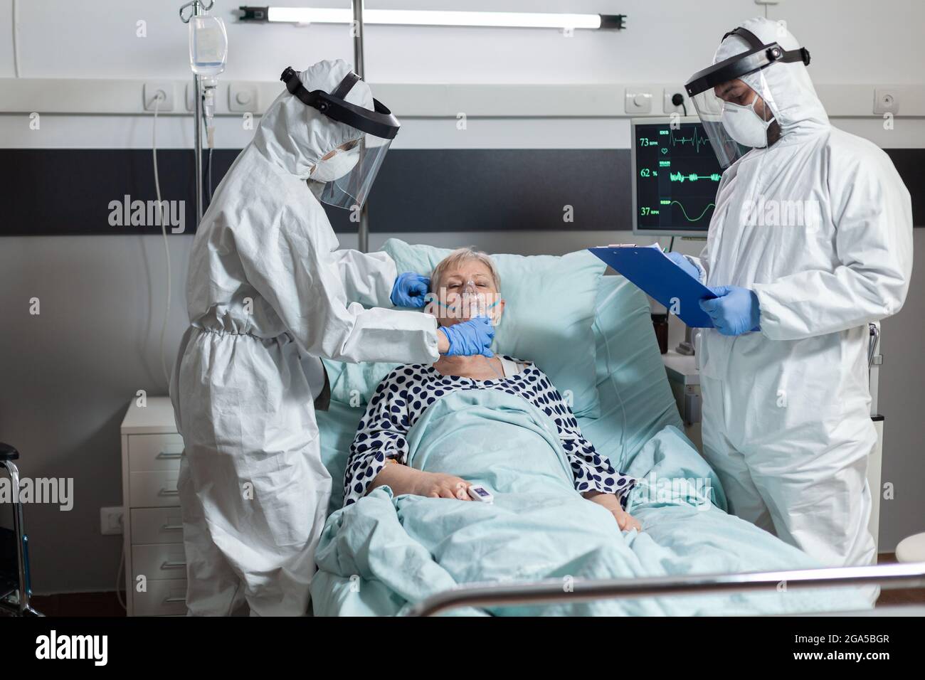 Medical team in clinic wearing coverall ppe and face shield during ...