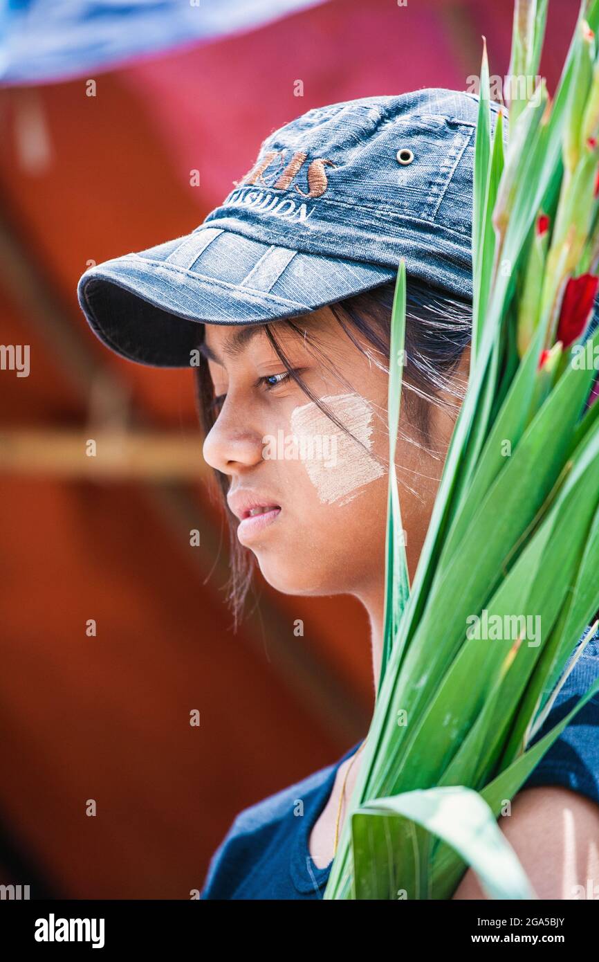 Pretty Burmese girl wearing baseball cap with thanaka face powder ...