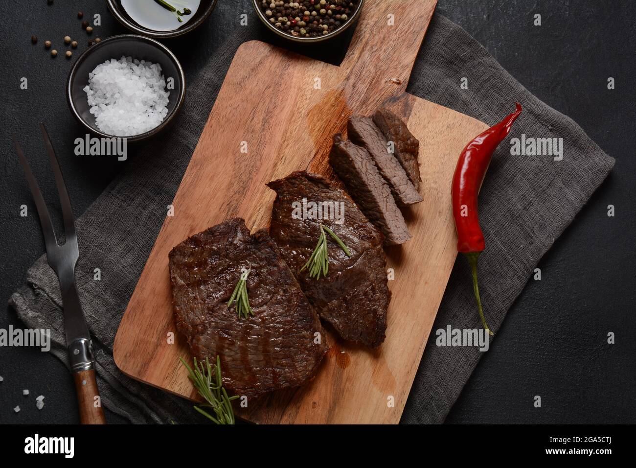 Grilled juicy beef steak with rosemary, fried meat, close-up. Top Blade ...