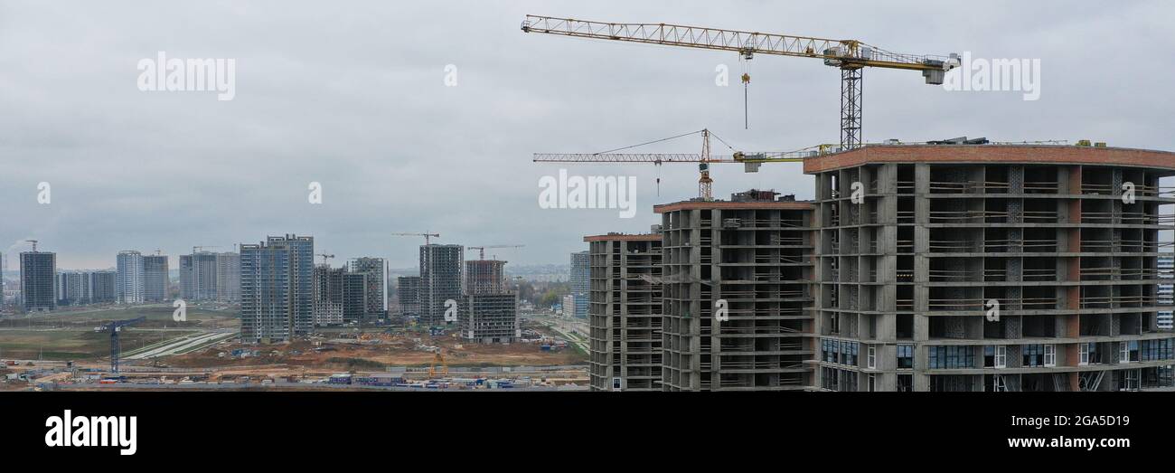 Construction cranes standing near multi storey buildings Stock Photo ...