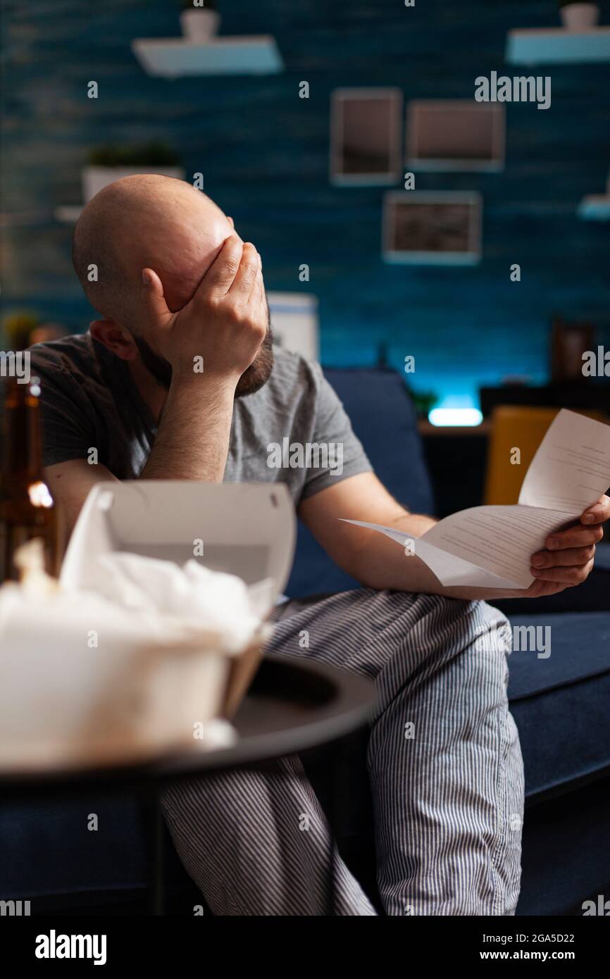 Desperate, depressed, frustrated man reading renter paper letter with ...