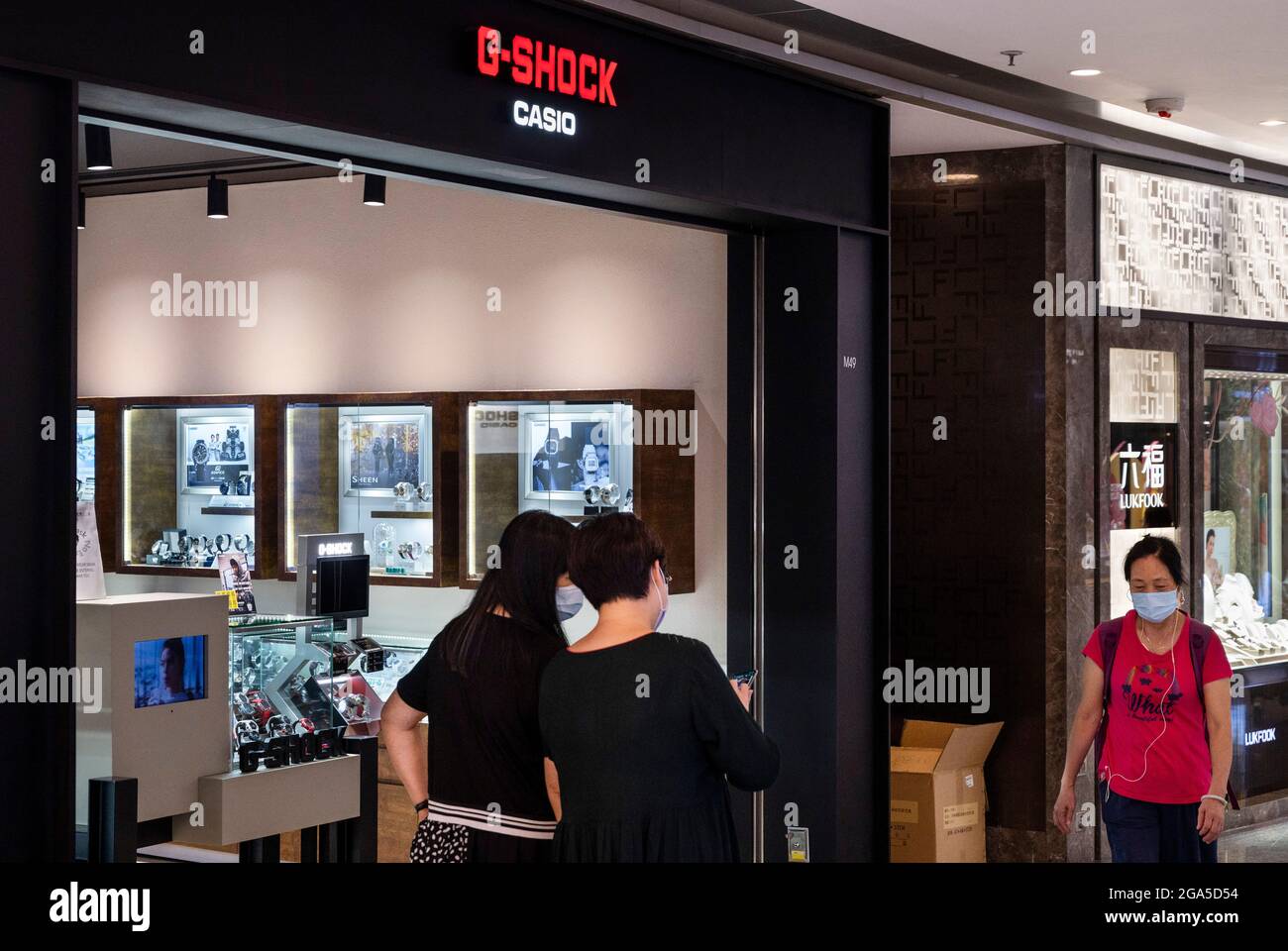 Shoppers walk past the Japanese multinational electronics manufacturing ...