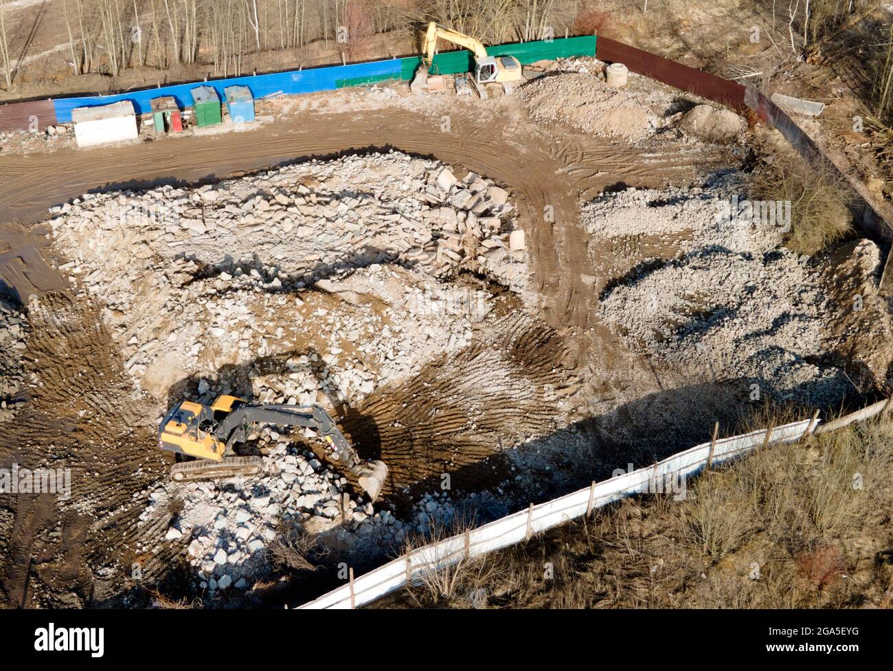 Recycling concrete and construction waste from demolition. Excavator at ...