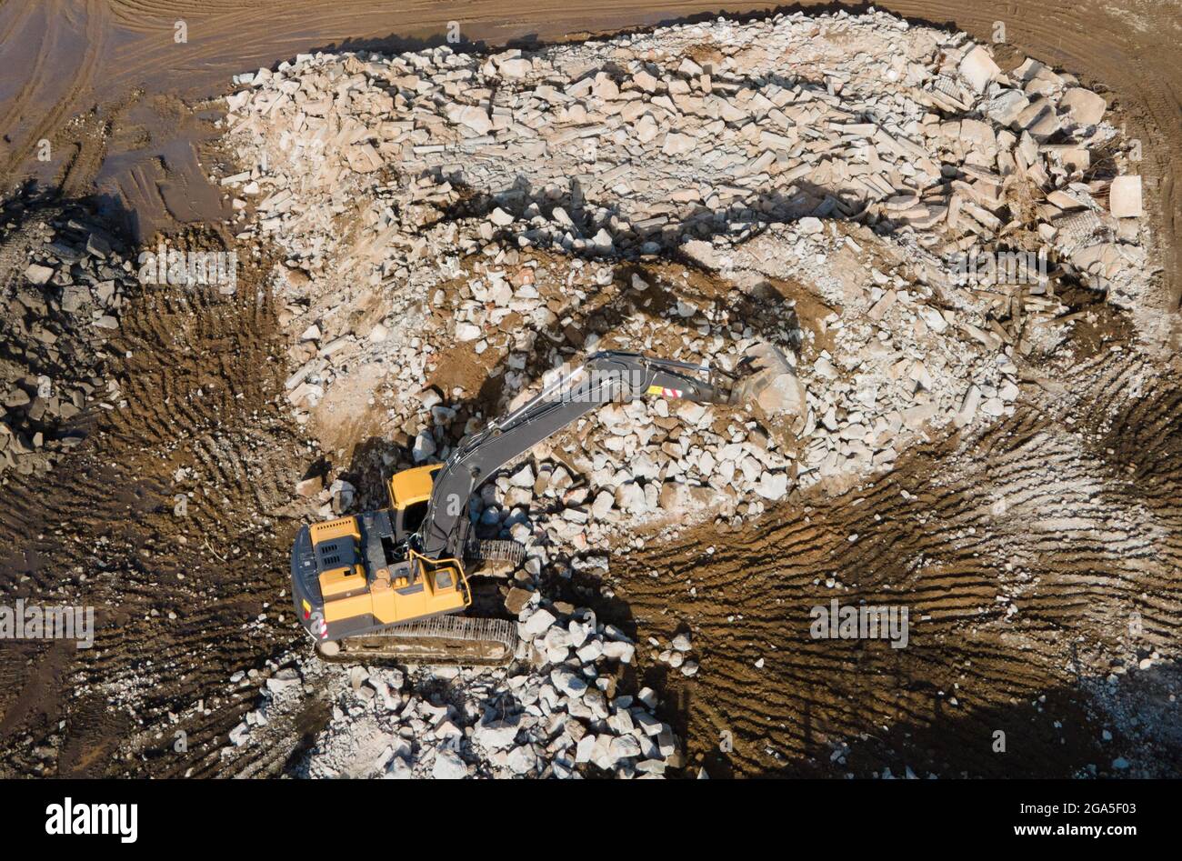 Recycling concrete and construction waste from demolition. Excavator at ...