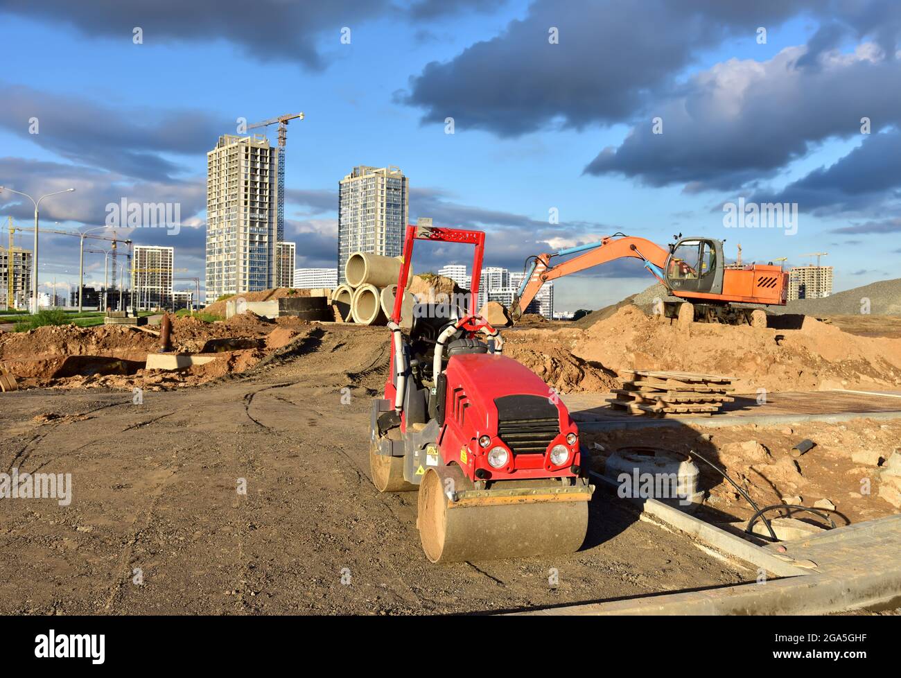 Excavator and road roller at road construction. Asphalt paver machine ...