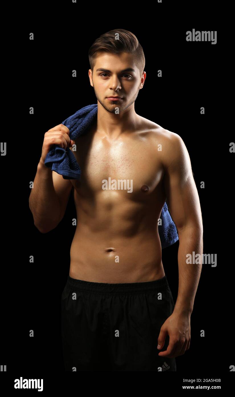 Muscle young man holding towel on dark background Stock Photo - Alamy