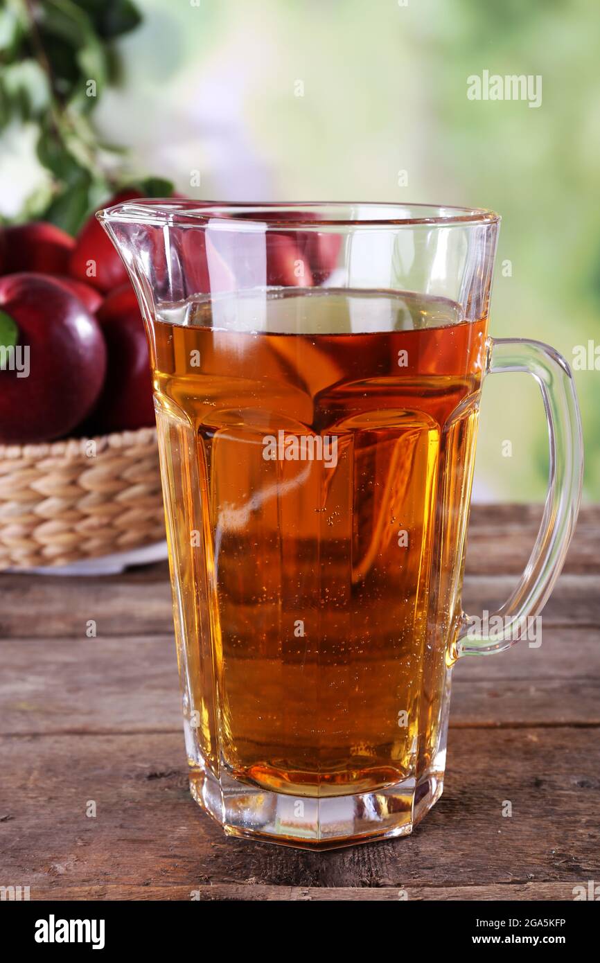 Full jug of apple juice and fruits on bright background Stock Photo - Alamy