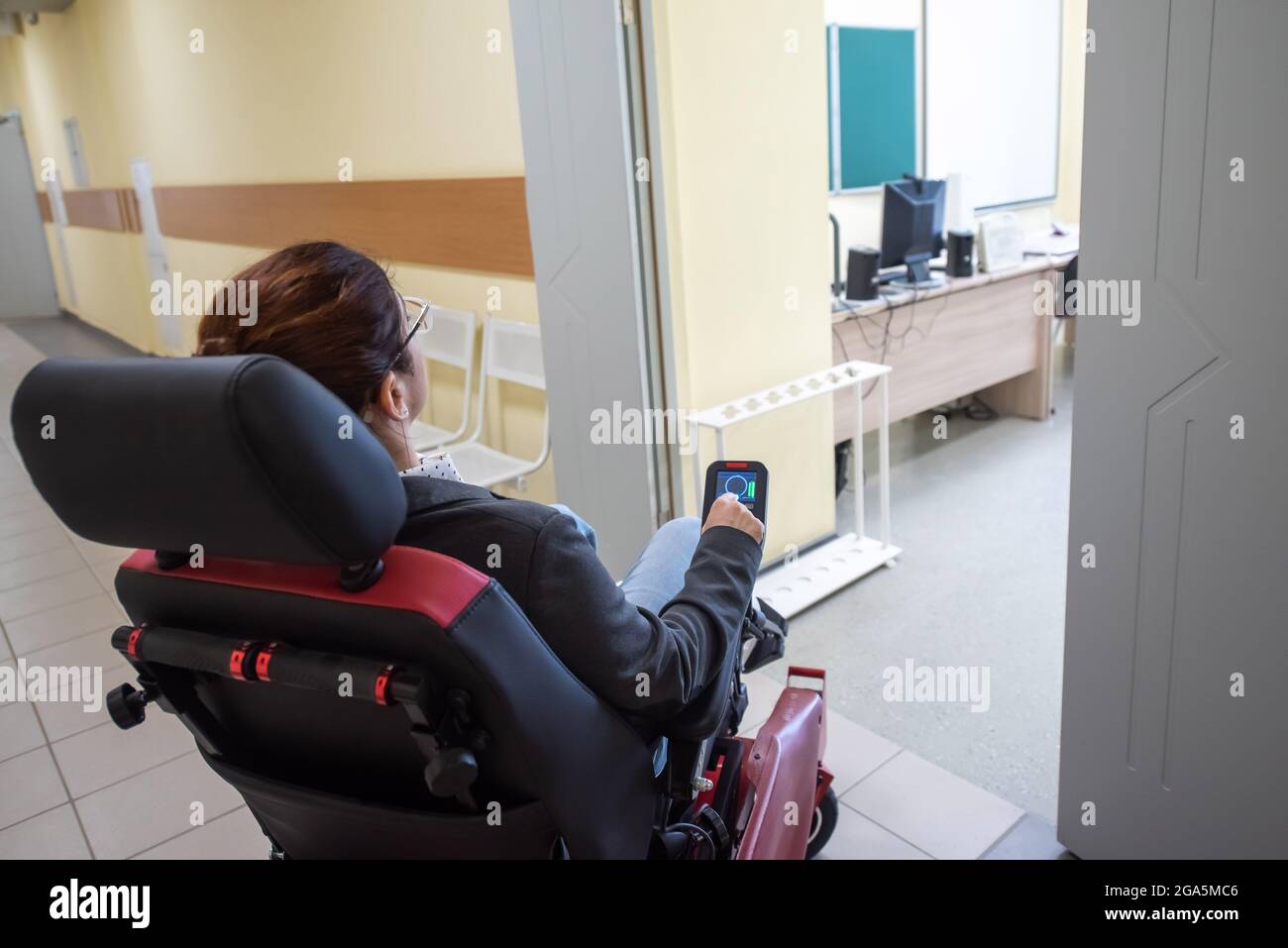 Caucasian woman in electric wheelchair in university corridor Stock ...