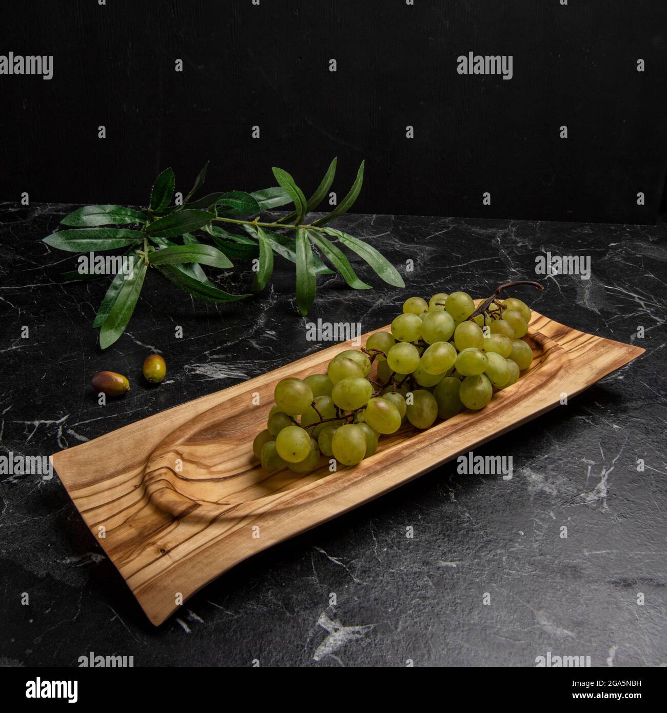 hand crafted olive wood plate with grapes Stock Photo - Alamy