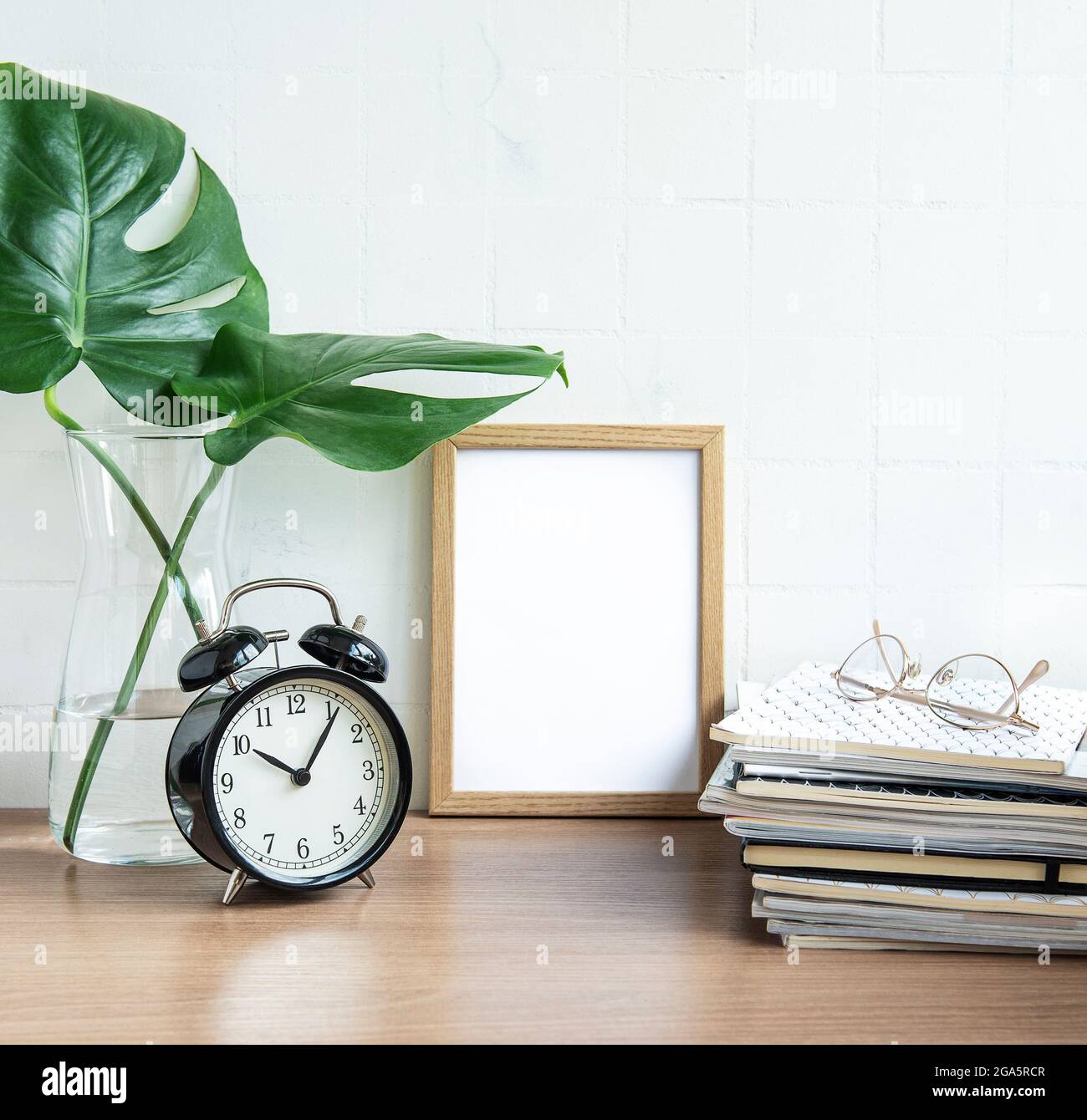 Office desk with stack of notepads, alarm clock, office supplies and ...