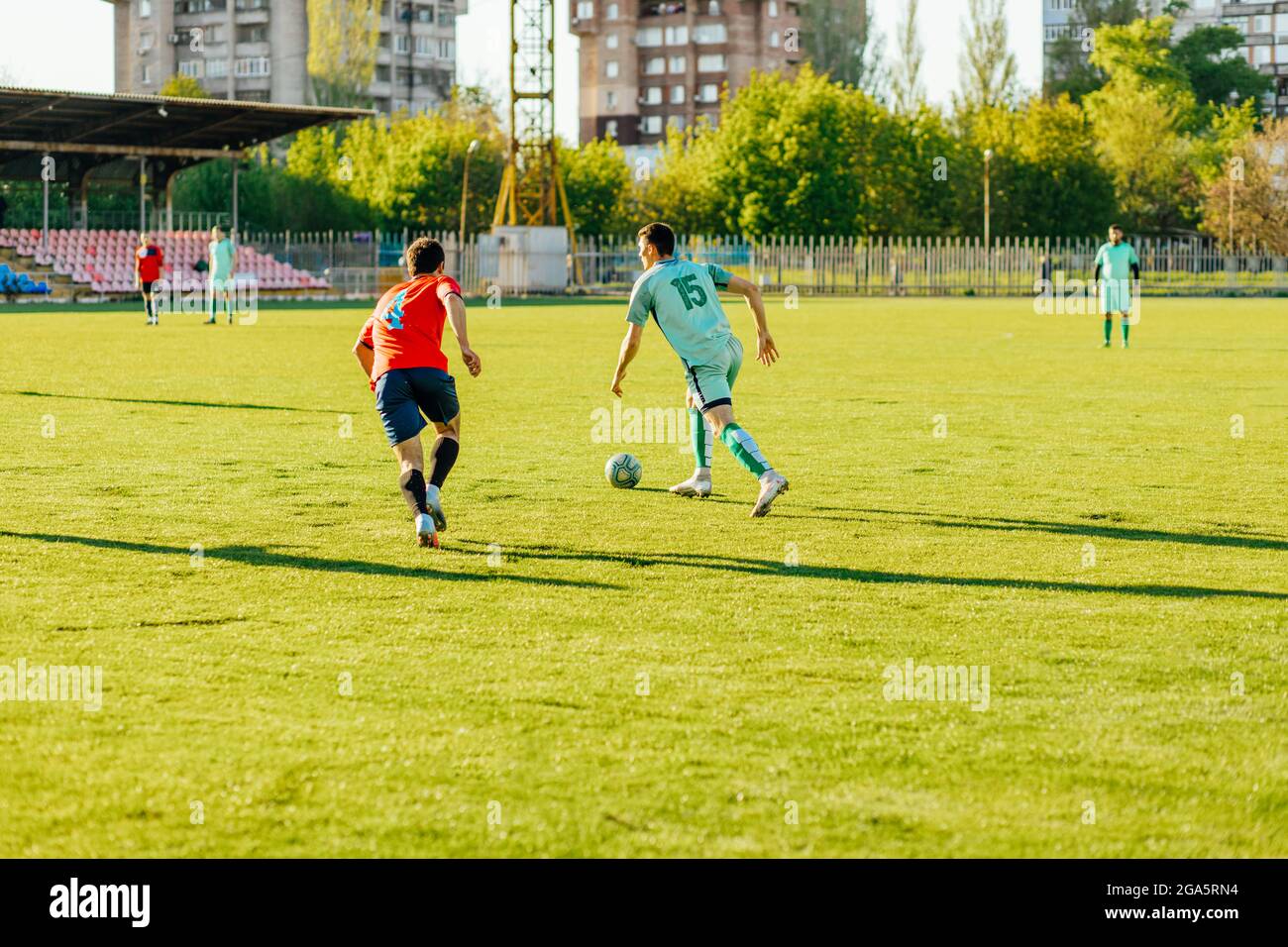 football players in action in the stadium, Football game for adults ...