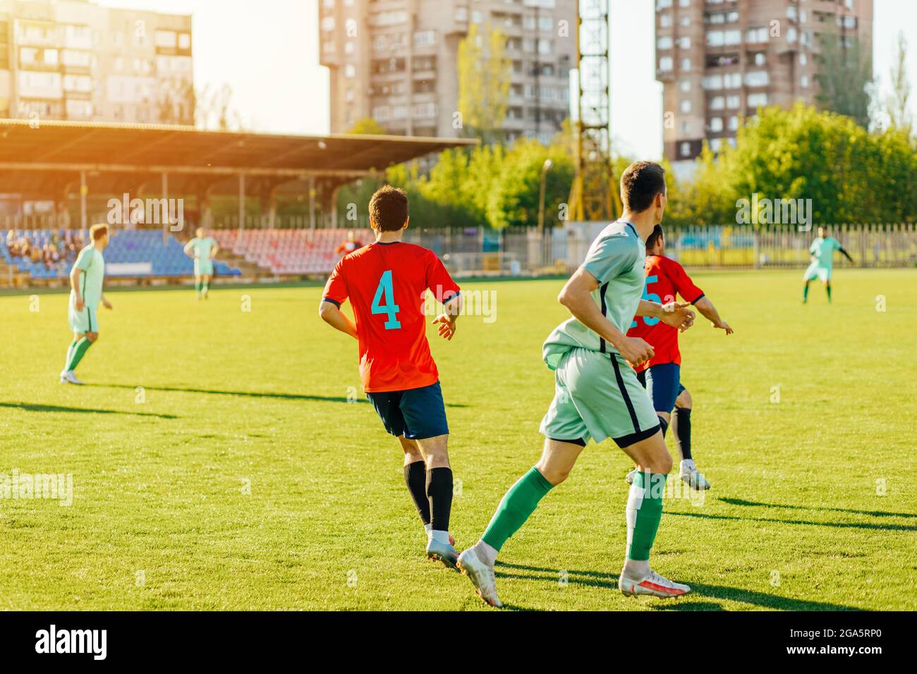 football players in action in the stadium, Football game for adults ...