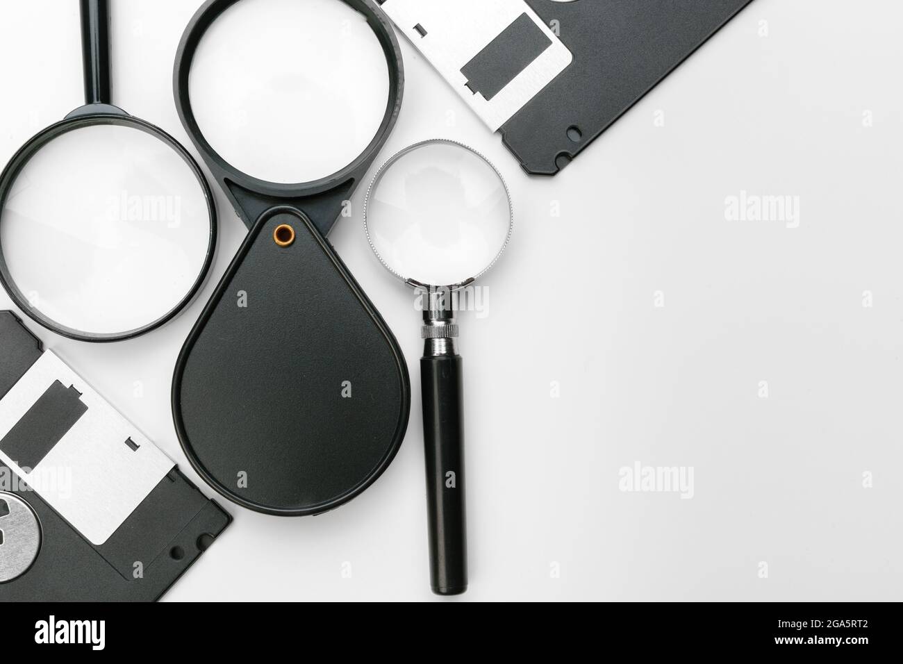 magnifying glass inspecting on floppy disk concept Stock Photo - Alamy