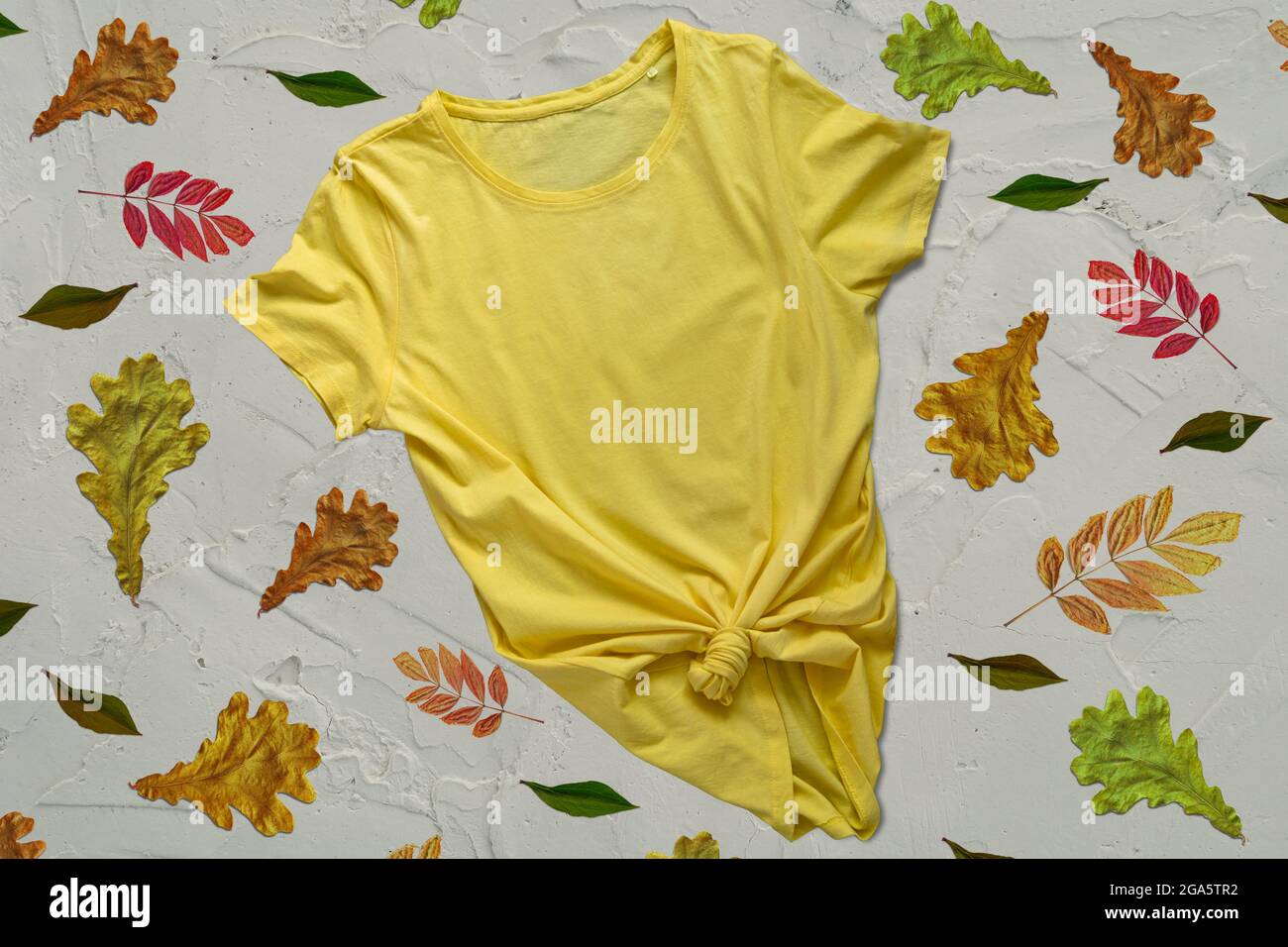 Yellow plain t-shirt mockup colorful autumn leaves gray background ...