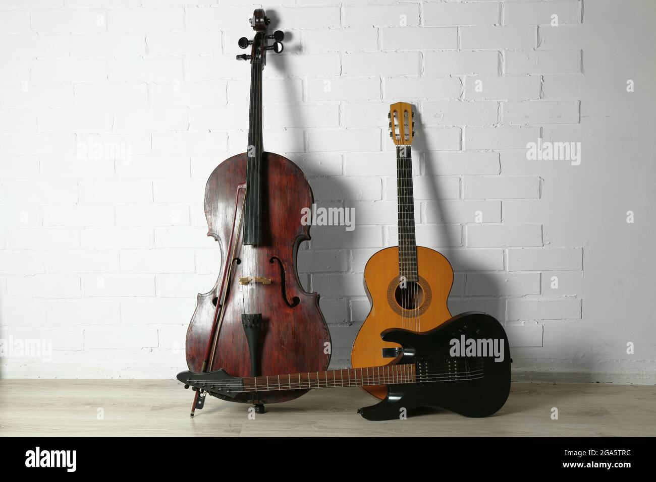 Musical instruments on white brick wall background Stock Photo - Alamy