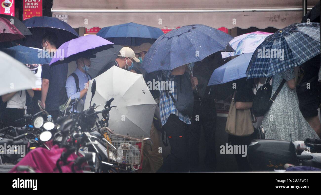 People hold umbrellas walking in the rain in Shanghai, China, 28 July ...