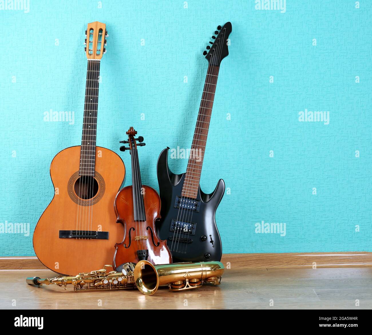Musical instruments on turquoise wallpaper background Stock Photo - Alamy