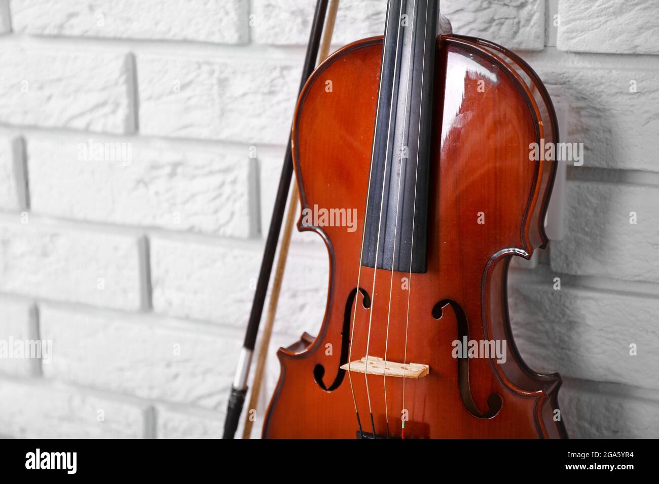 Violin on bricks wall background Stock Photo - Alamy