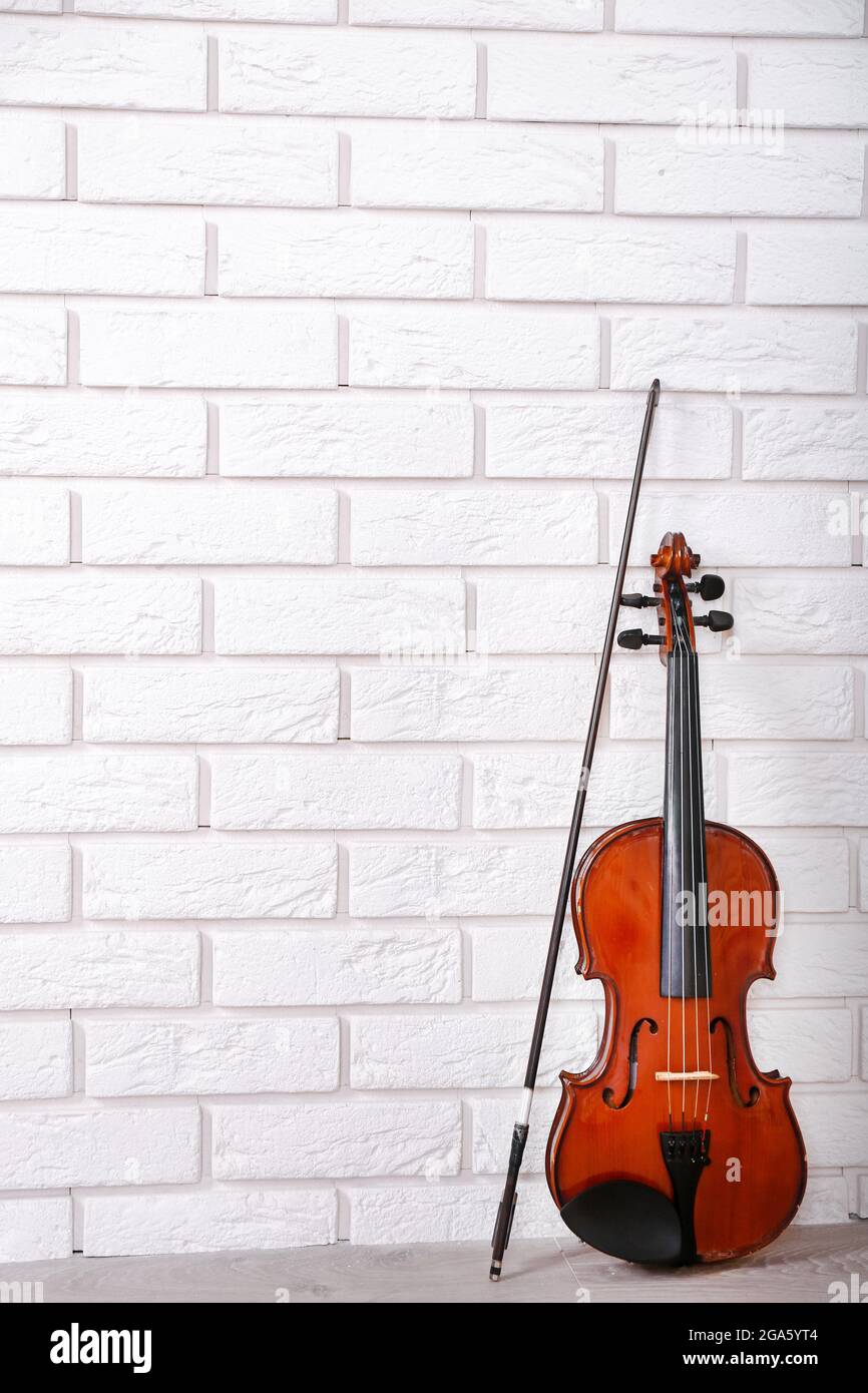Violin on bricks wall background Stock Photo - Alamy