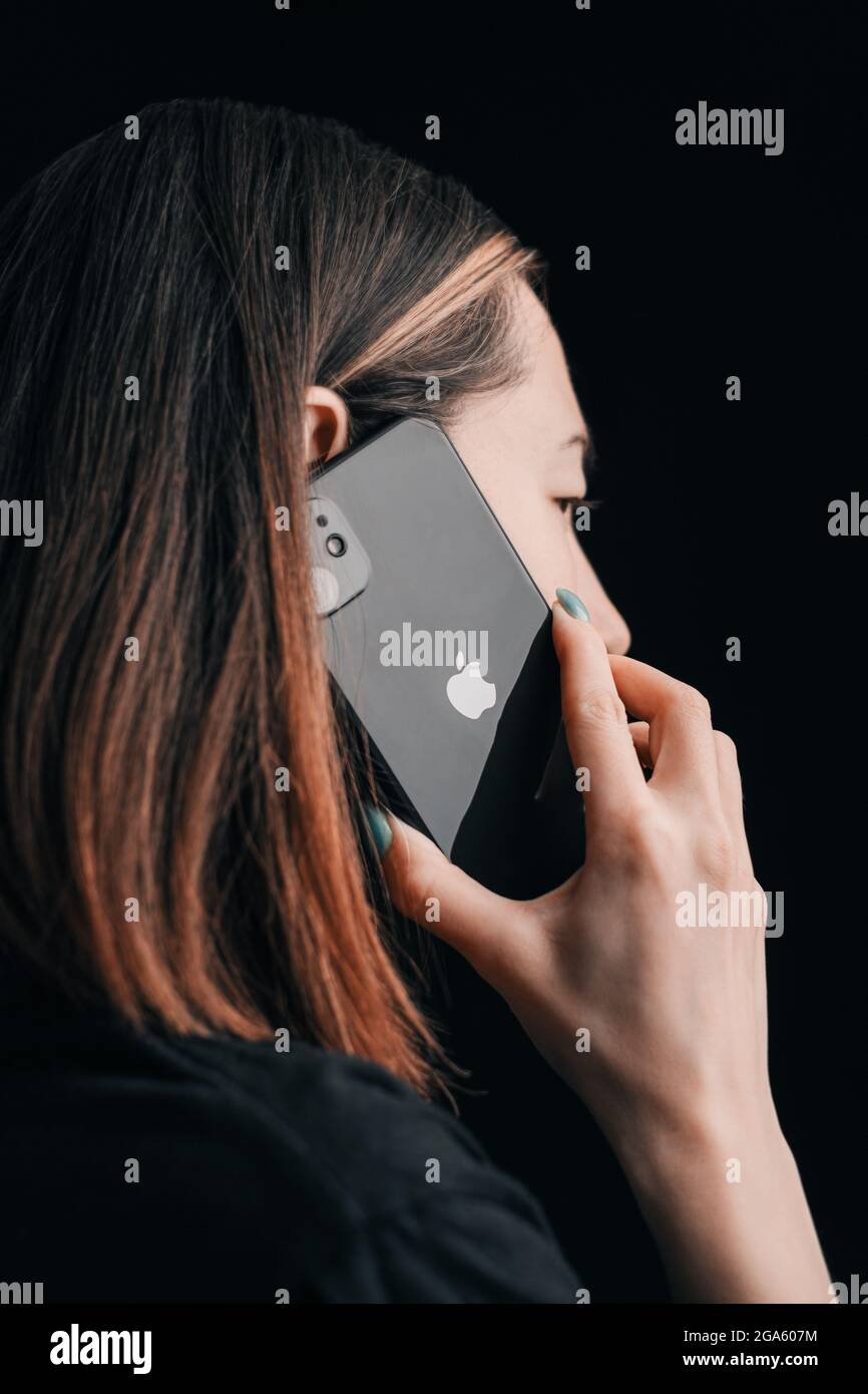 The young woman is talking on the iPhone 11. The Apple logo is deployed ...