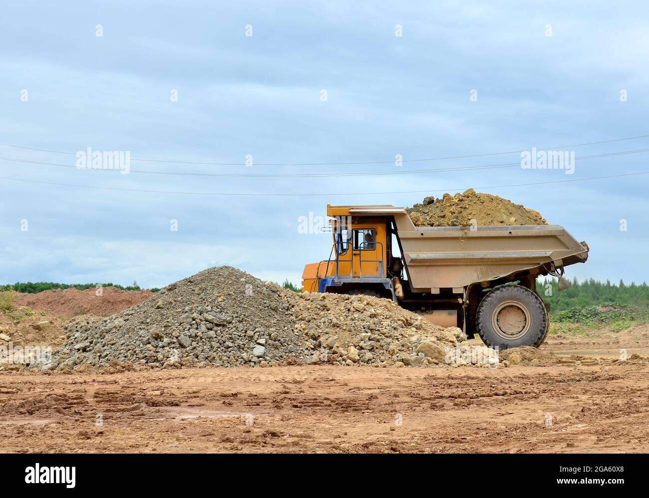 Mining truck and excavators working in the limestone open-pit. Loading ...
