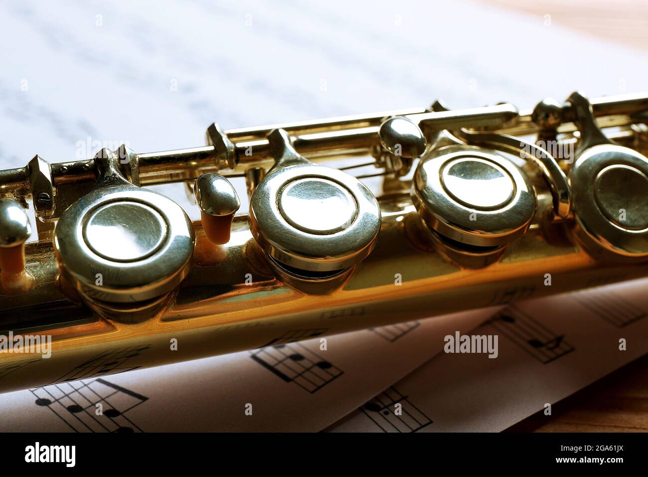 Silver flute on music notes background Stock Photo - Alamy
