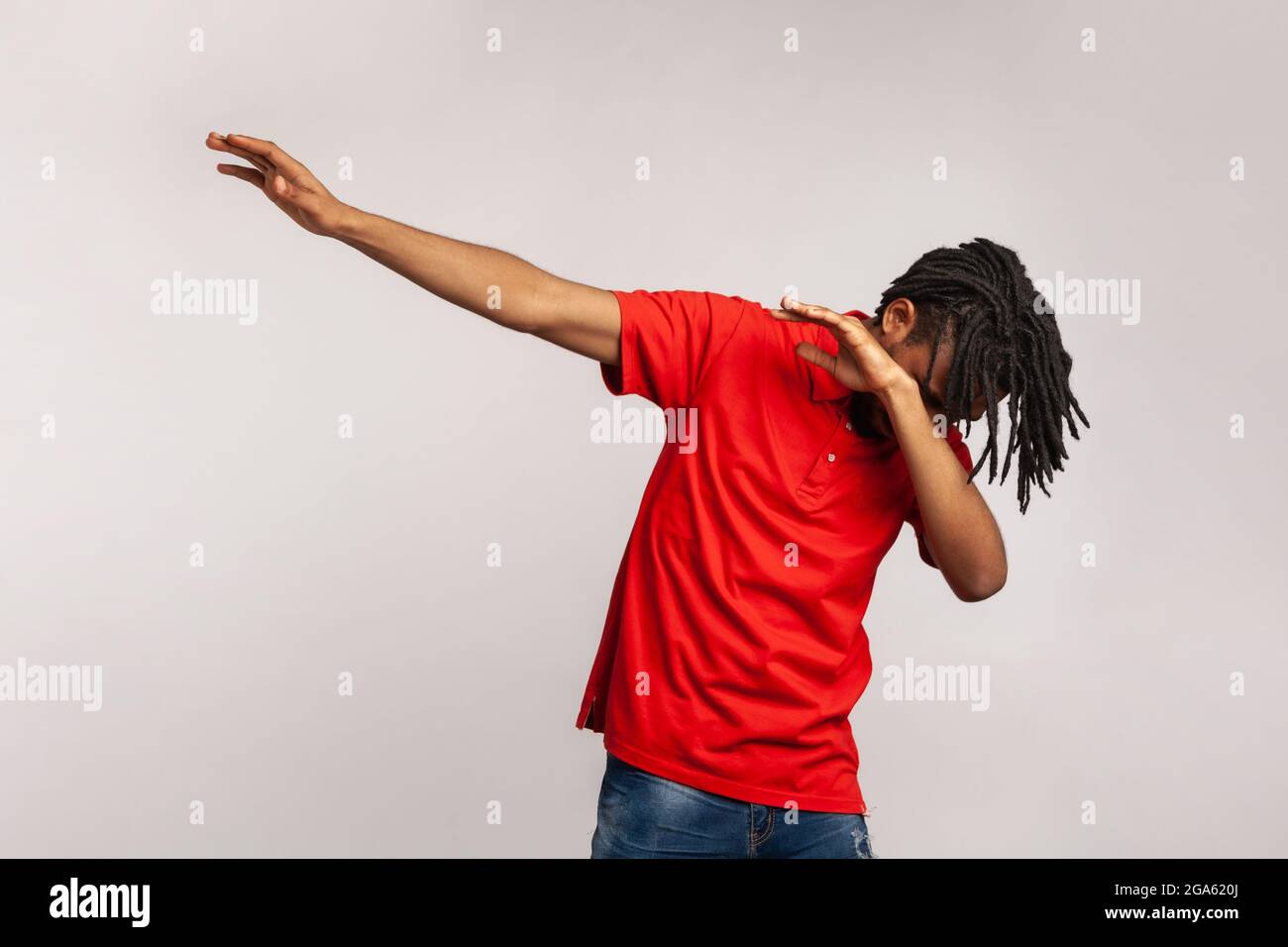 Portrait of young adult man with dreadlocks wearing red casual style T ...