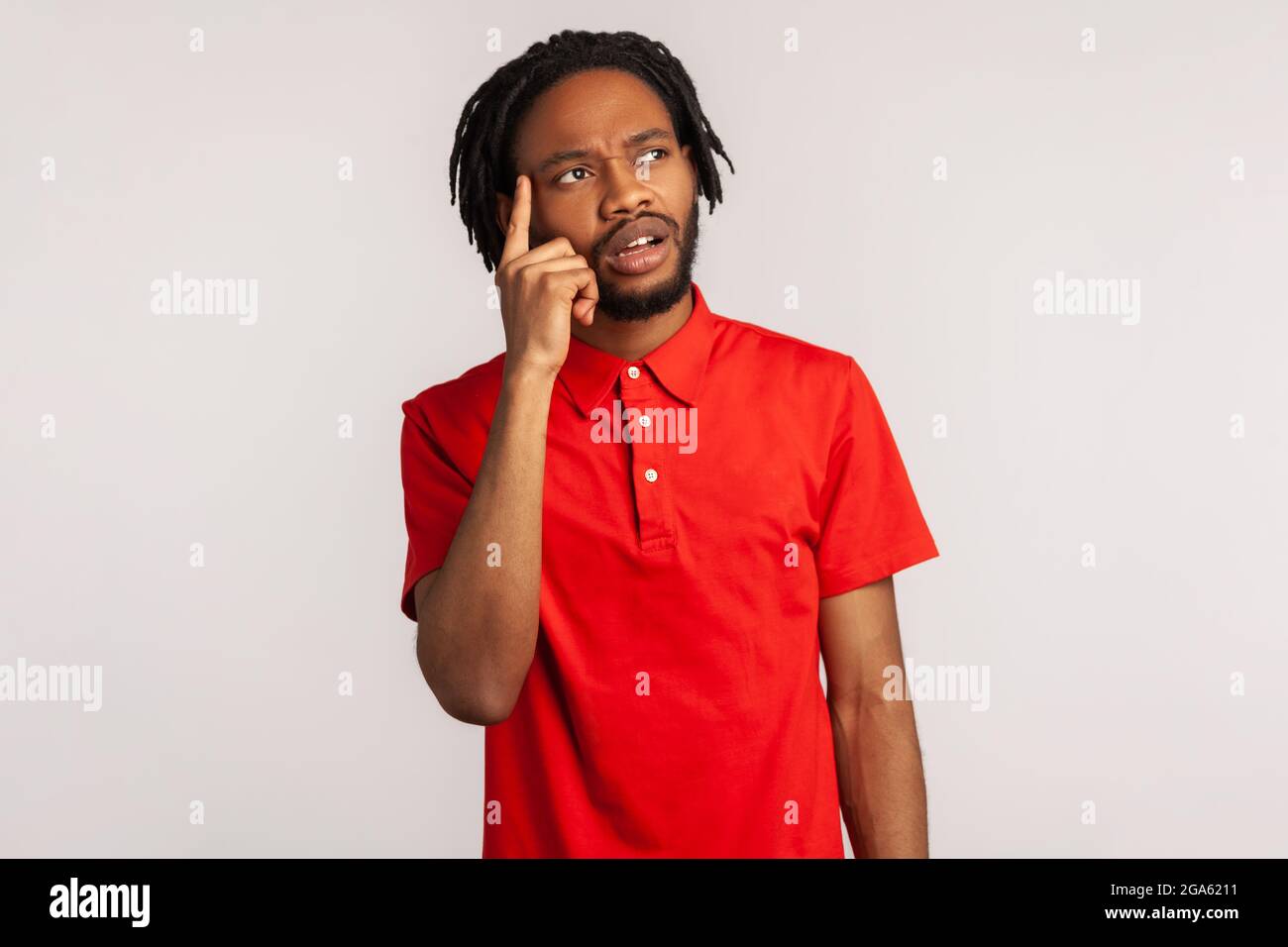 Portrait of young attractive bearded man with dreadlocks wearing red ...