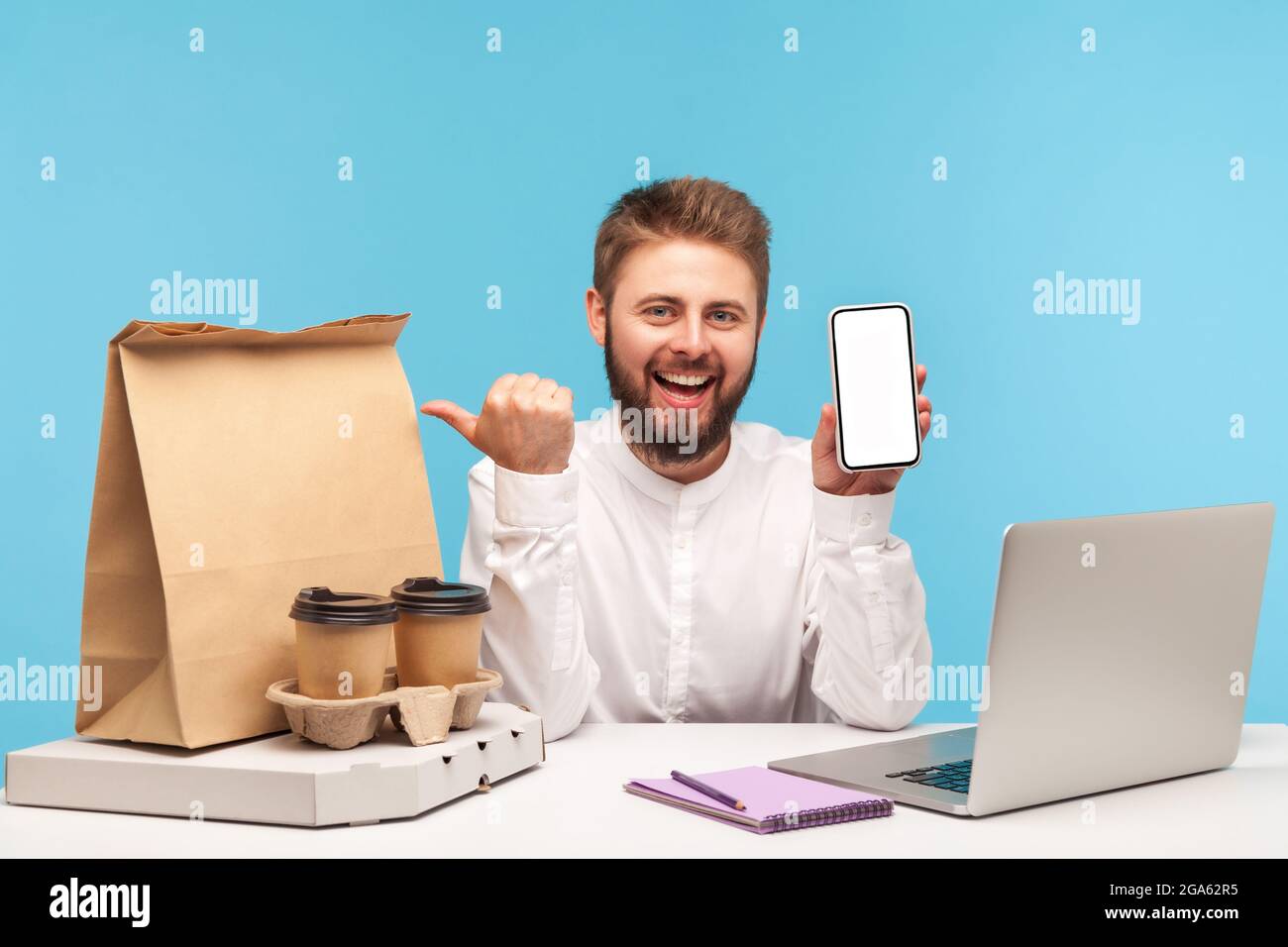 Smiling Bearded Man Holding White Screen Smartphone Pointing Finger At