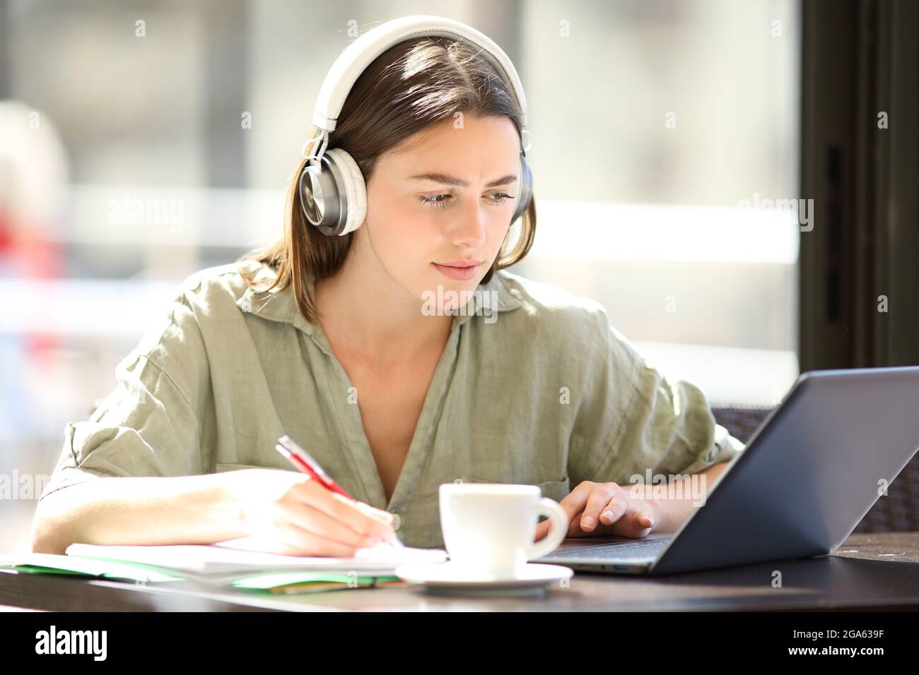 Concentrated student e-learning with a laptop and headphones in a ...