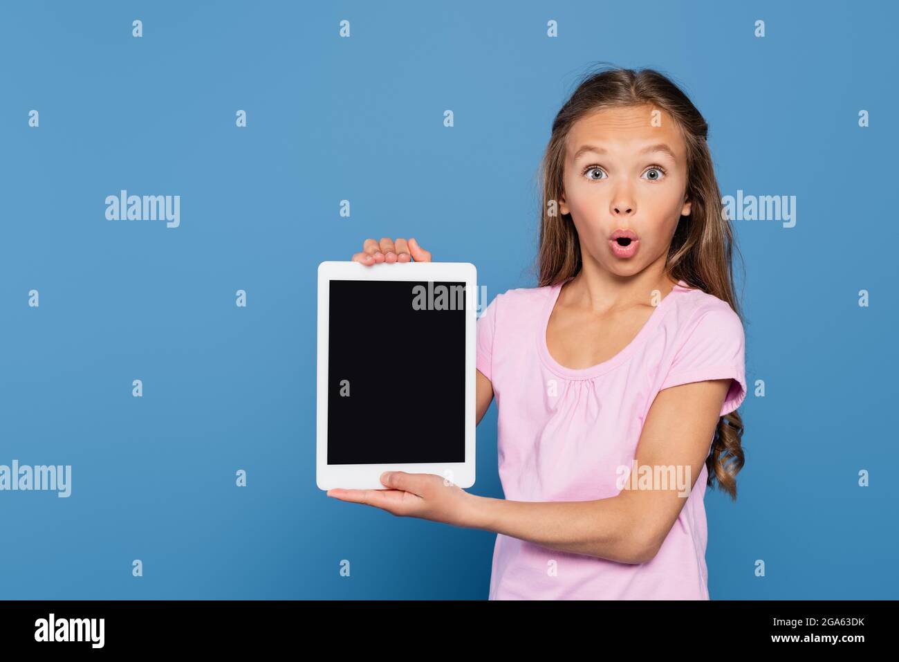 Astonished kid holding digital tablet with blank screen isolated on ...