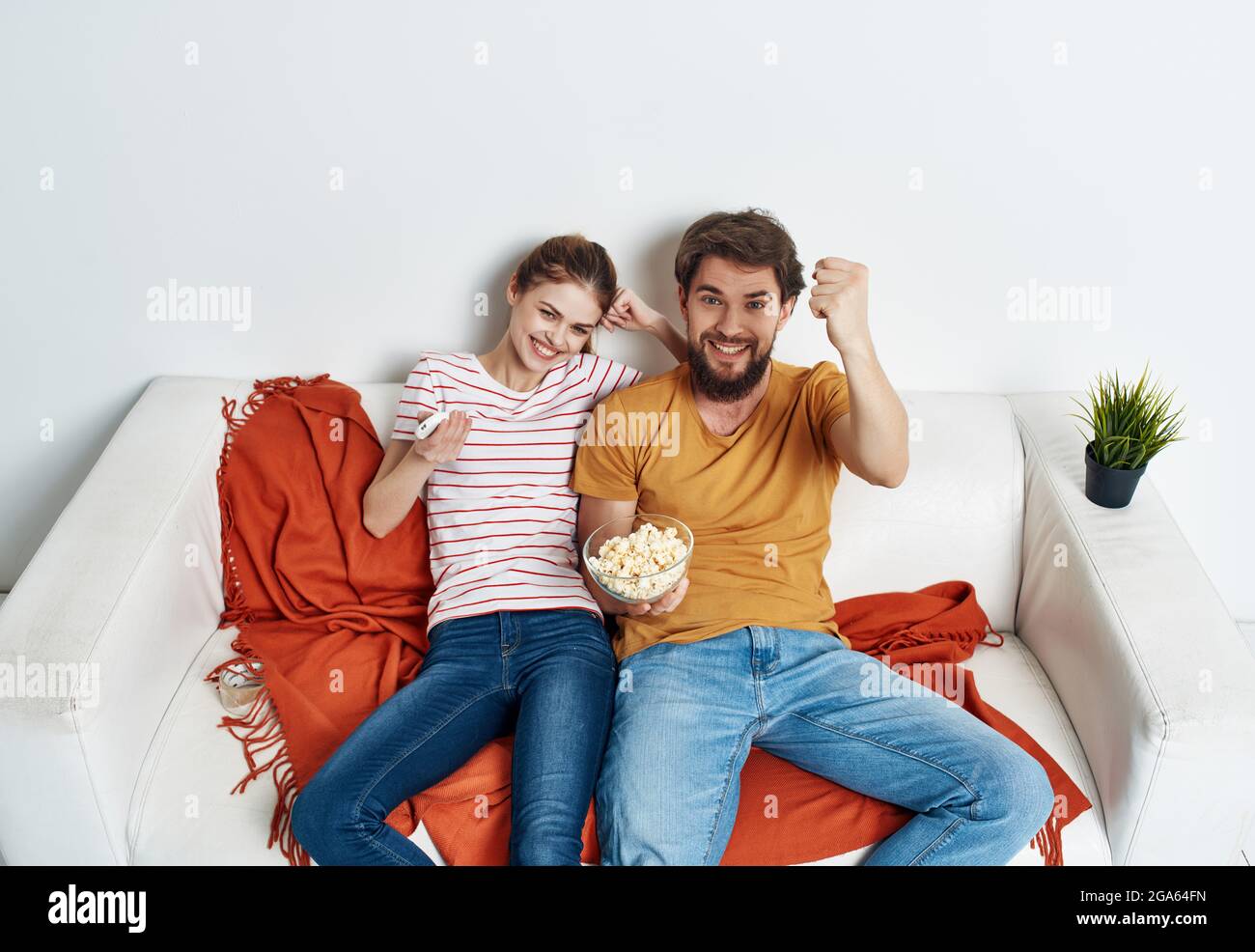 young couple sitting on the couch popcorn watching a movie vacation ...