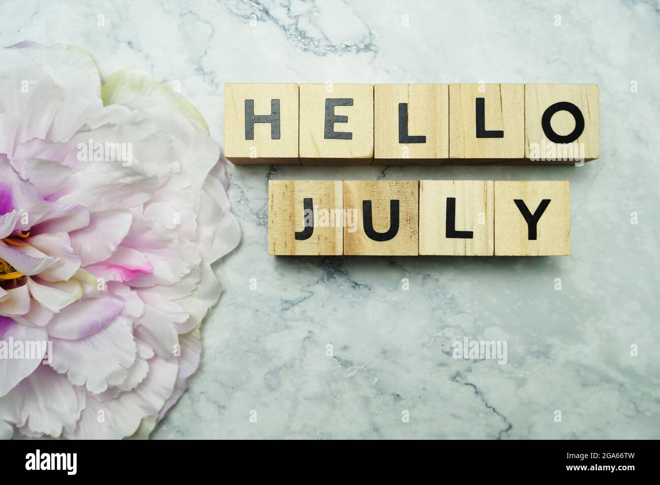 Hello July alphabet letters with pink flower decoration on marble ...