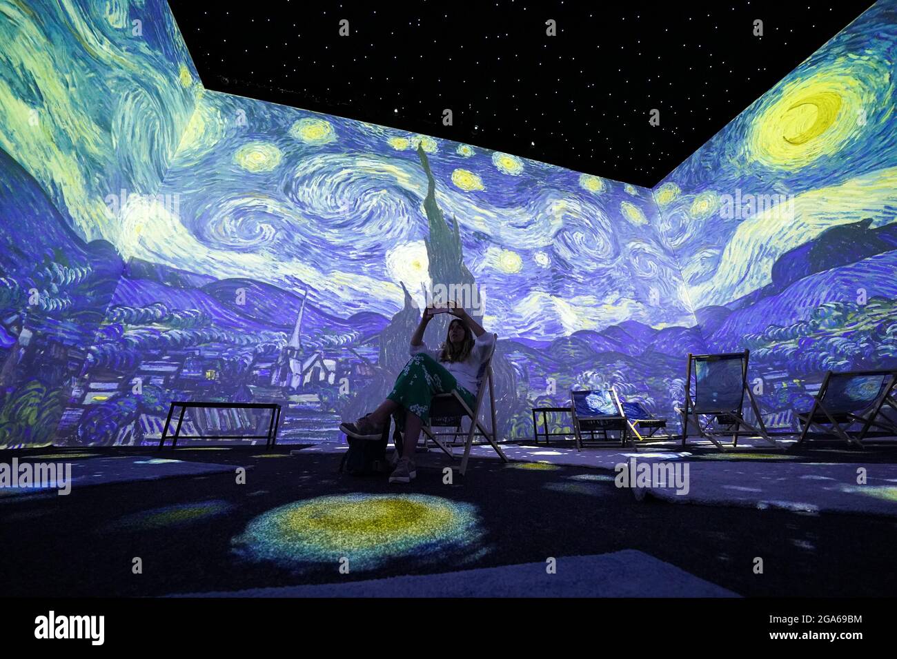 A women films a projection which is part of the Van Gogh: The Immersive ...