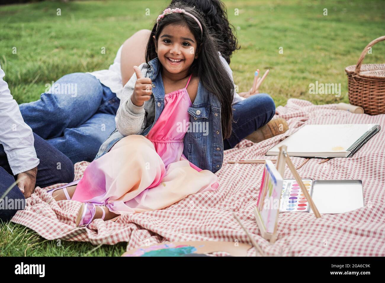 Happy indian family having fun painting with children outdoor at city ...