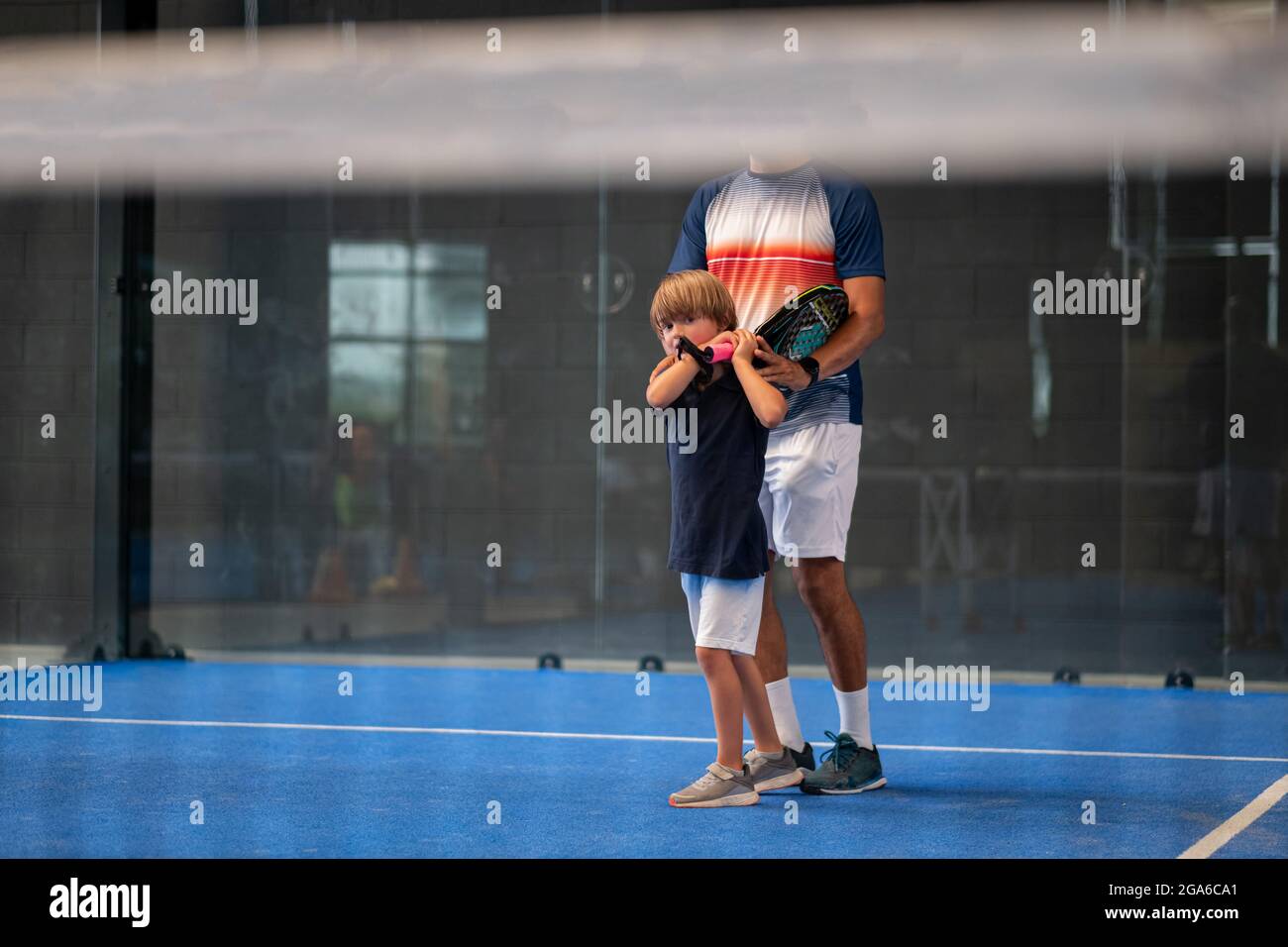 Monitor teaching padel class to child, his student - Trainer teaches ...
