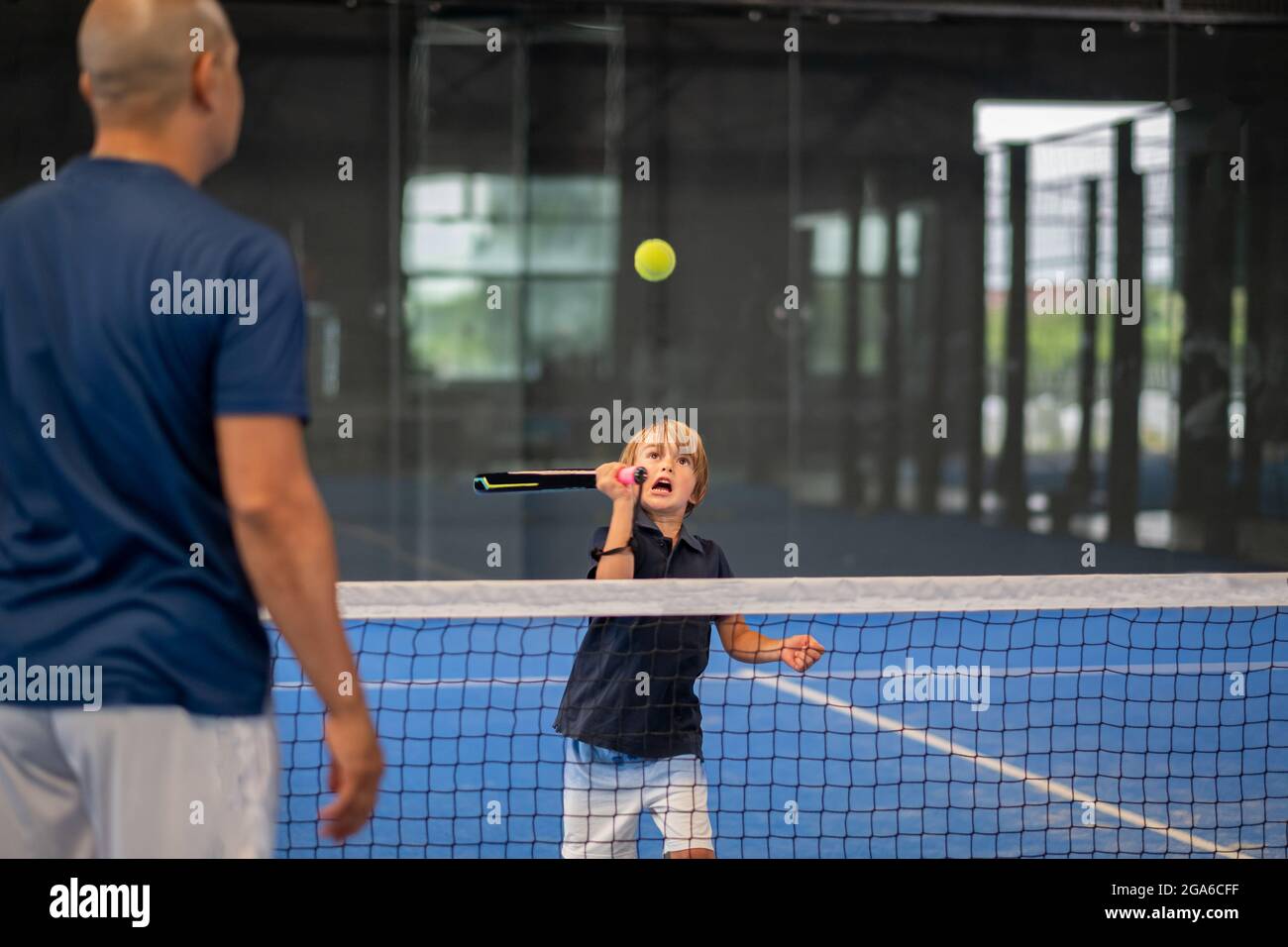 Monitor teaching padel class to child, his student - Trainer teaches ...