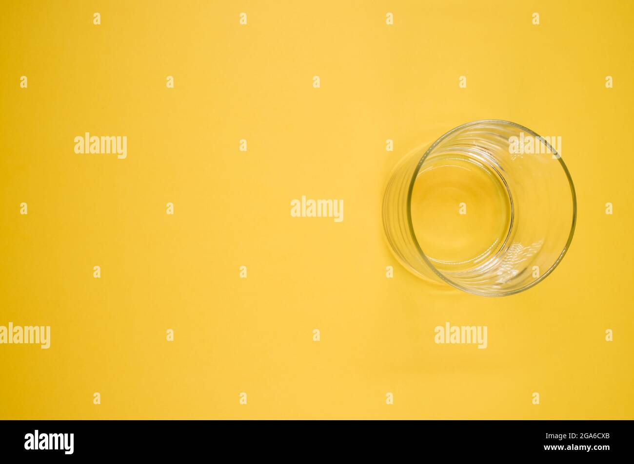 Top view shot of an empty glass on a yellow background Stock Photo - Alamy