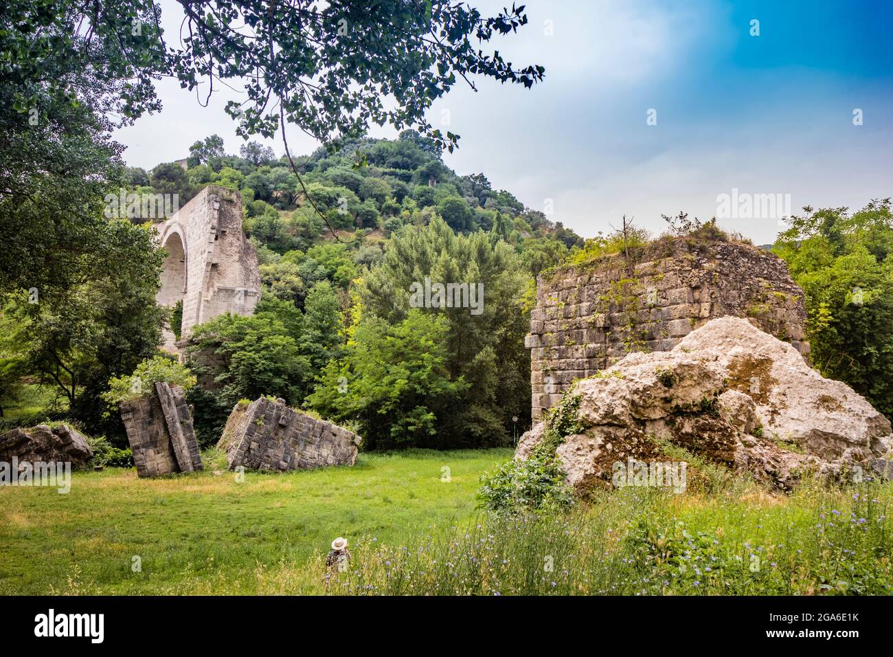 An artist paints live the ruins of the Roman arch bridge of Augustus ...