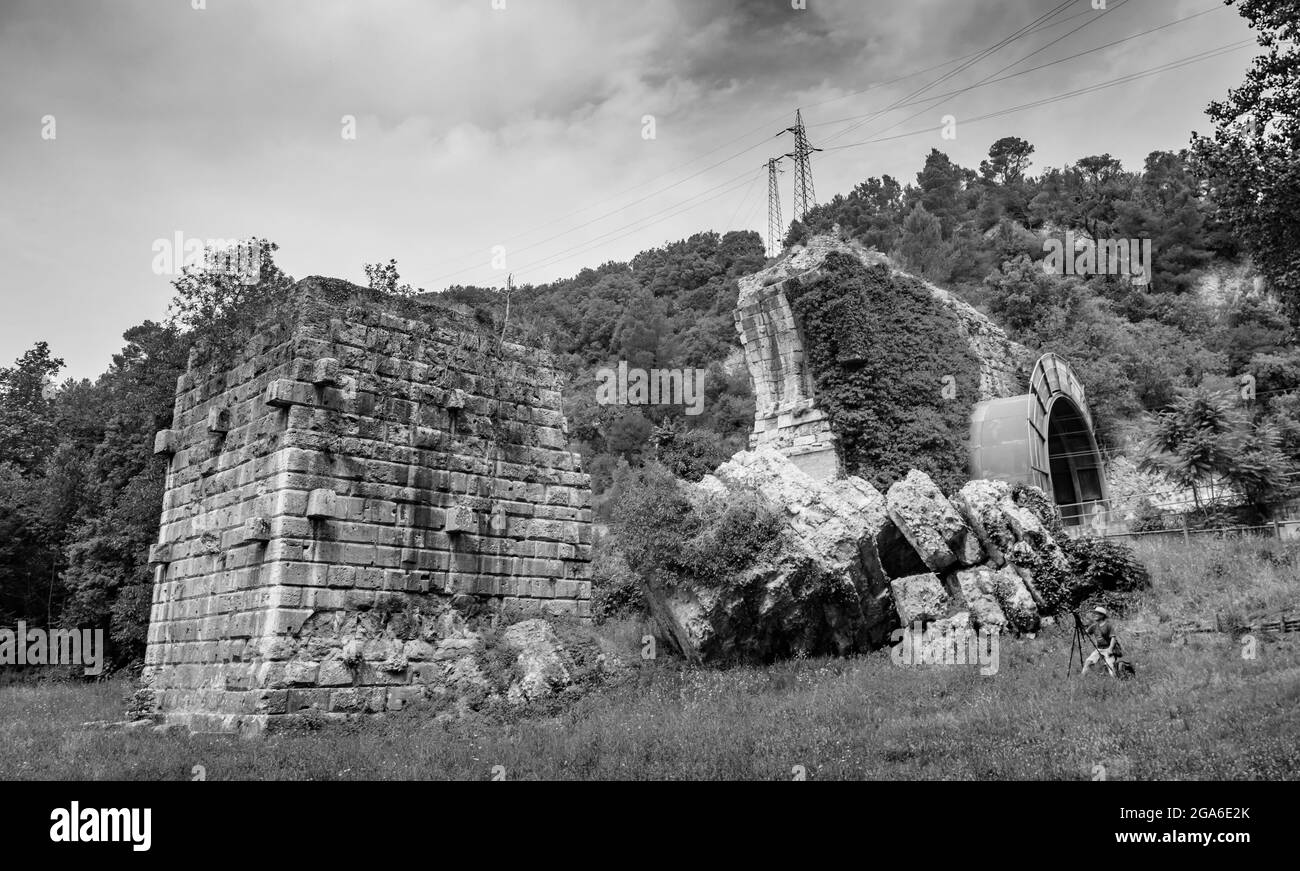 An artist paints live the ruins of the Roman arch bridge of Augustus ...