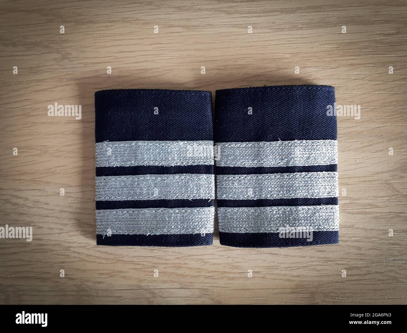 Couple of pilot’s epaulettes on a wooden surface Stock Photo - Alamy