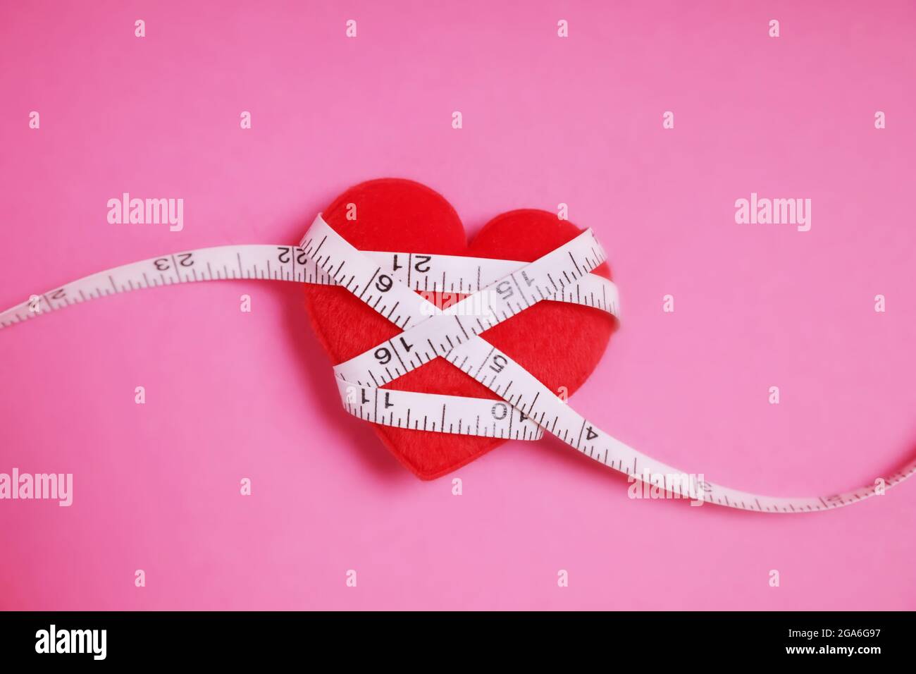 heart tape measure on a pink background.Communicate about love, hope ...