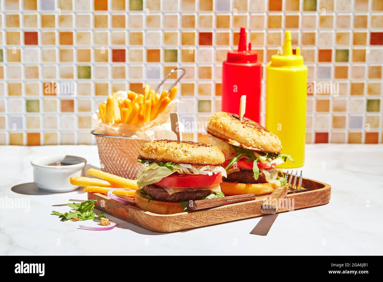 Delicious homemade burgers on wooden tray in bright sunlight. Burgers ...