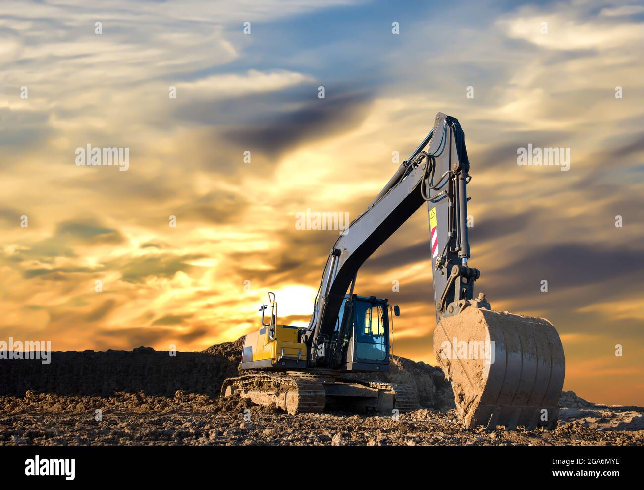 Excavator working on earthmoving at open pit mining on amazing sunset ...