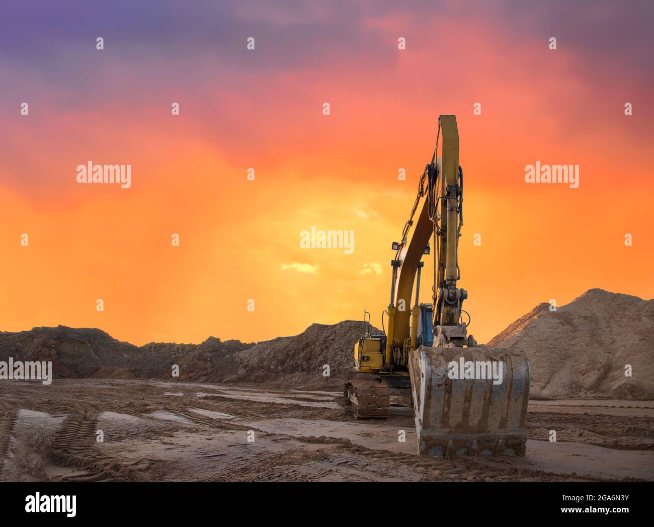 Excavator working on earthmoving at open pit mining on amazing sunset ...