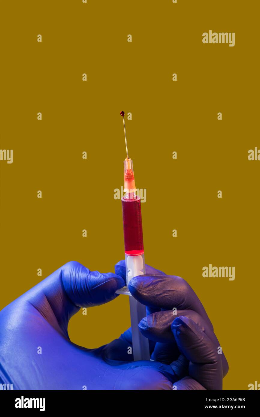 Doctor and nurse use protective gloves fill injection syringe with ...