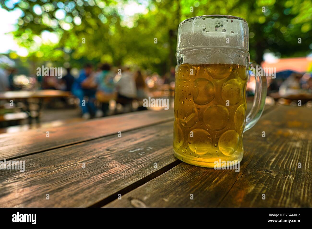 Glass of fresh beer in a traditional bavarian beer garden in Munich ...